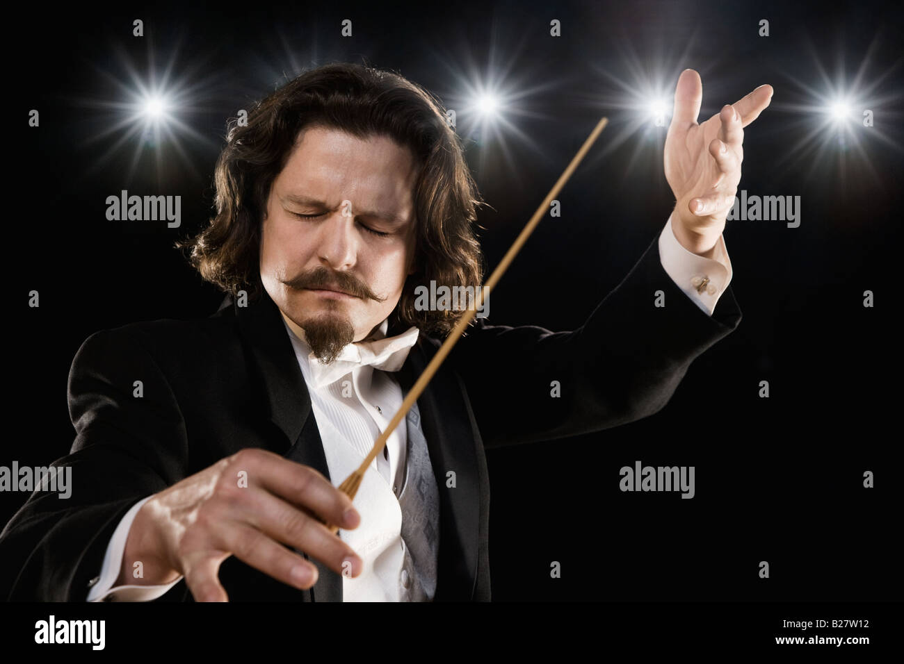 Man conducting under lights Stock Photo - Alamy