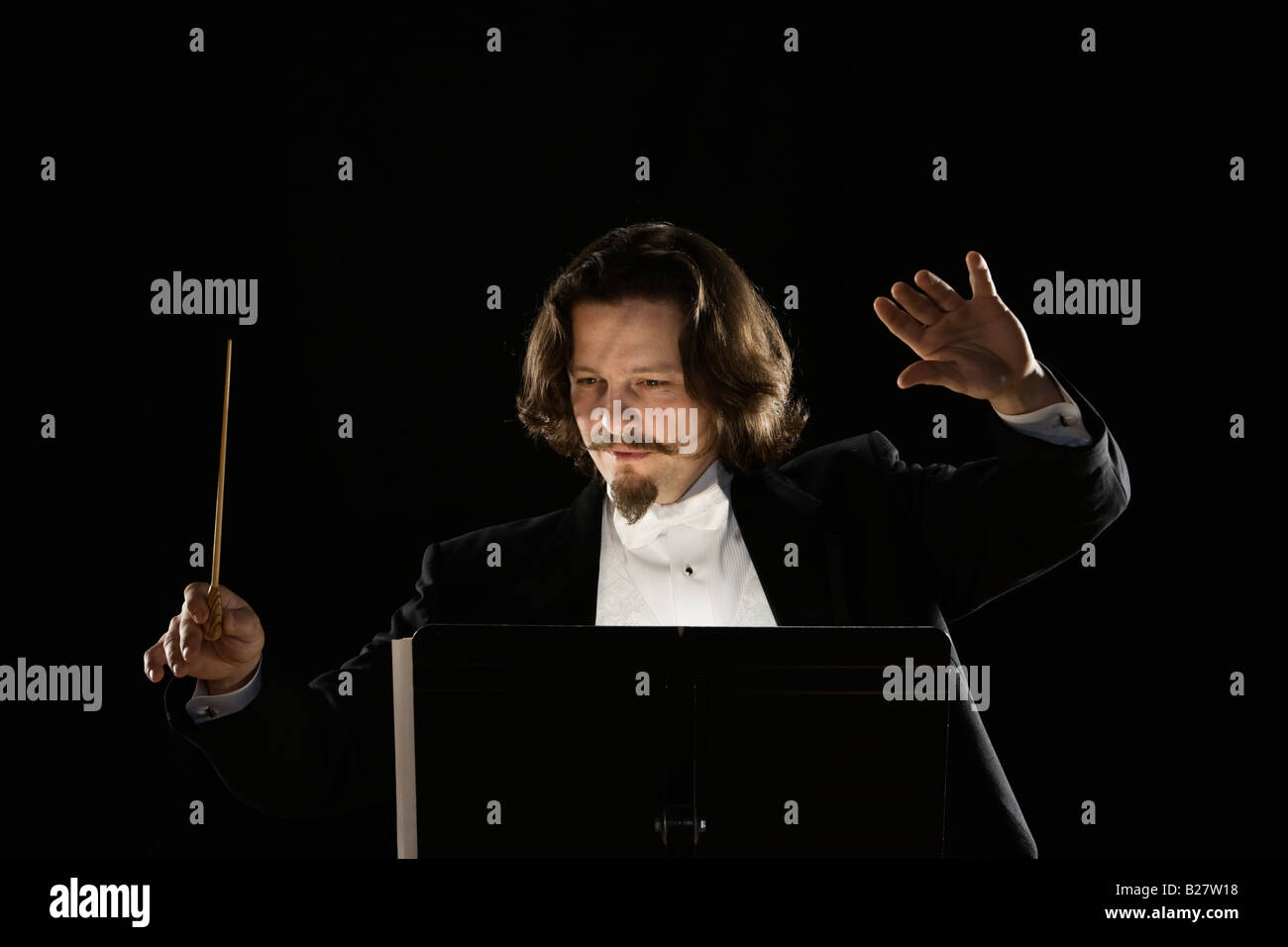 Man conducting behind music stand Stock Photo - Alamy