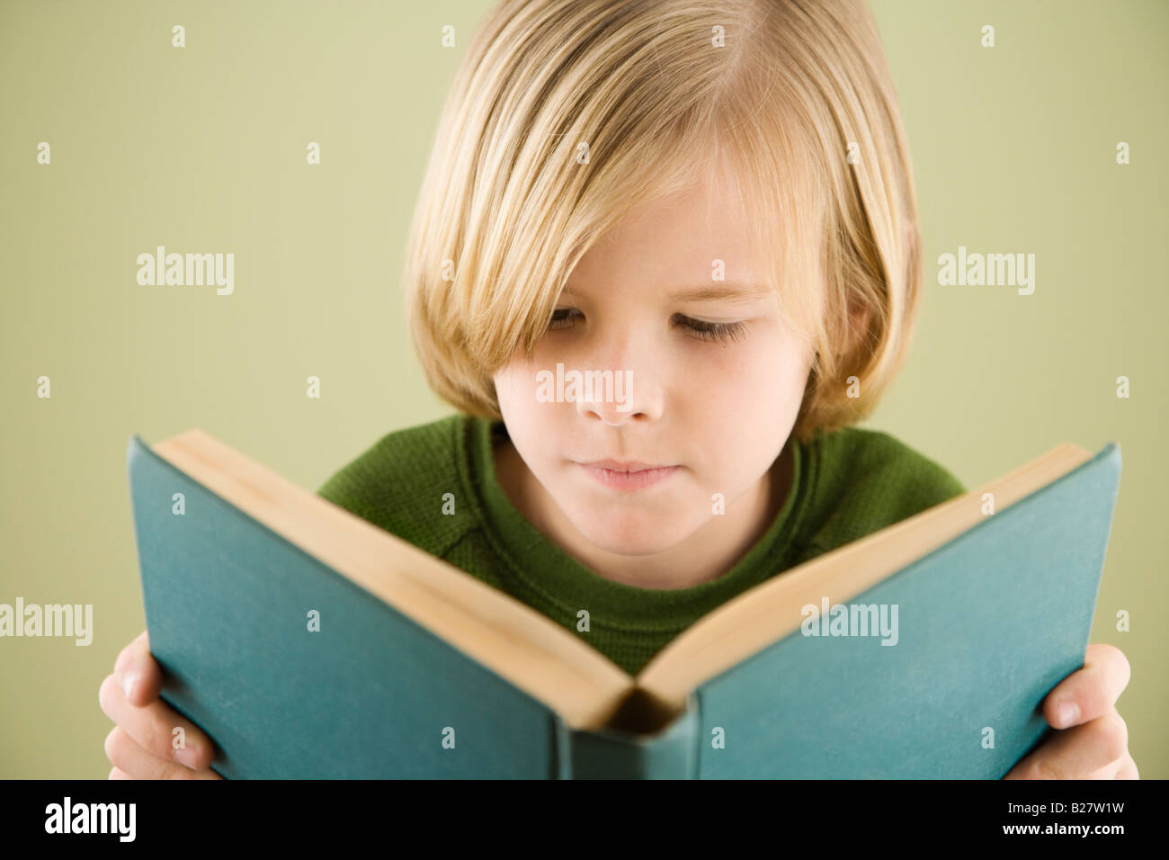 Boy reading book Stock Photo - Alamy