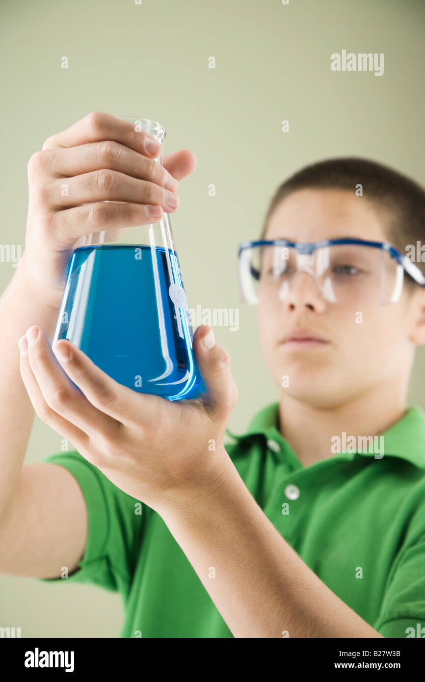 Boy looking at beaker of liquid Stock Photo - Alamy