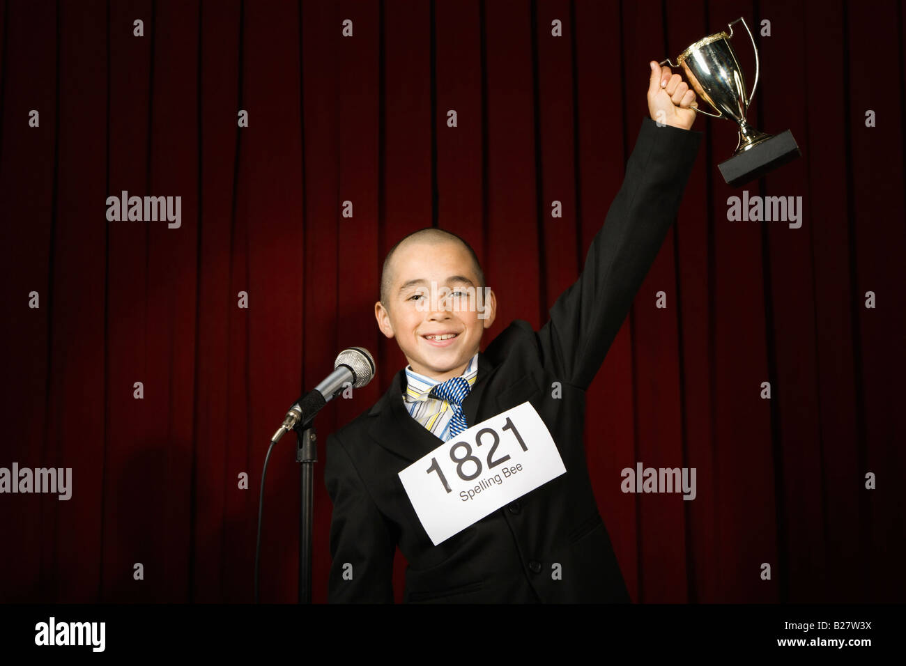 Boy wearing number and holding trophy Stock Photo - Alamy