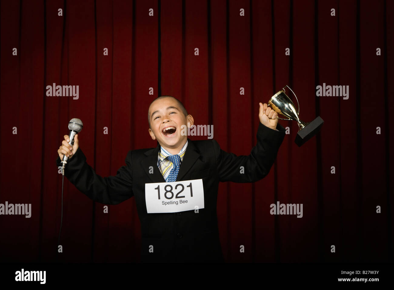 Boy wearing number and holding trophy Stock Photo - Alamy