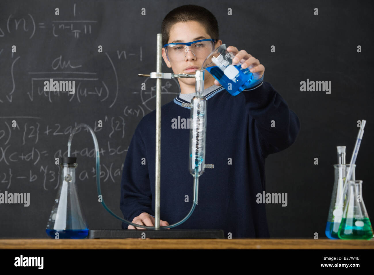 Boy pouring liquid in science class Stock Photo - Alamy