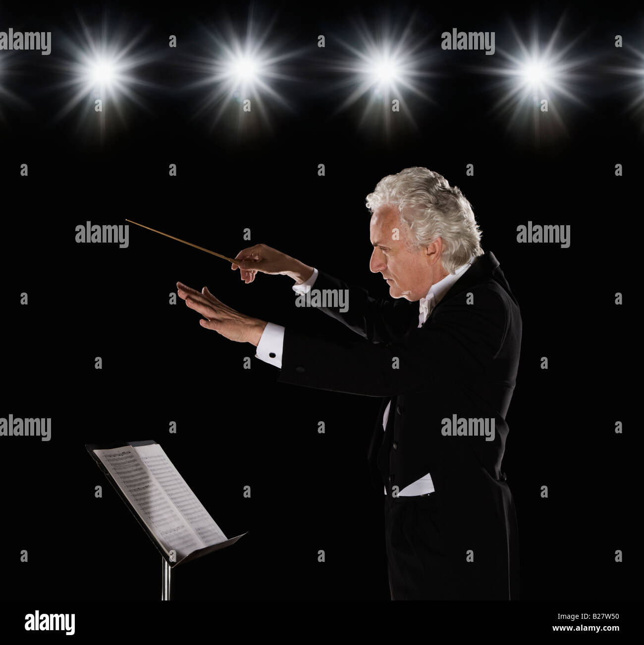 Man in tuxedo conducting under lights Stock Photo - Alamy