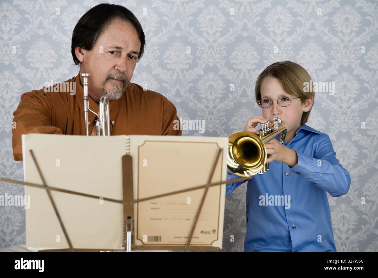 Boy playing trumpet for teacher Stock Photo - Alamy