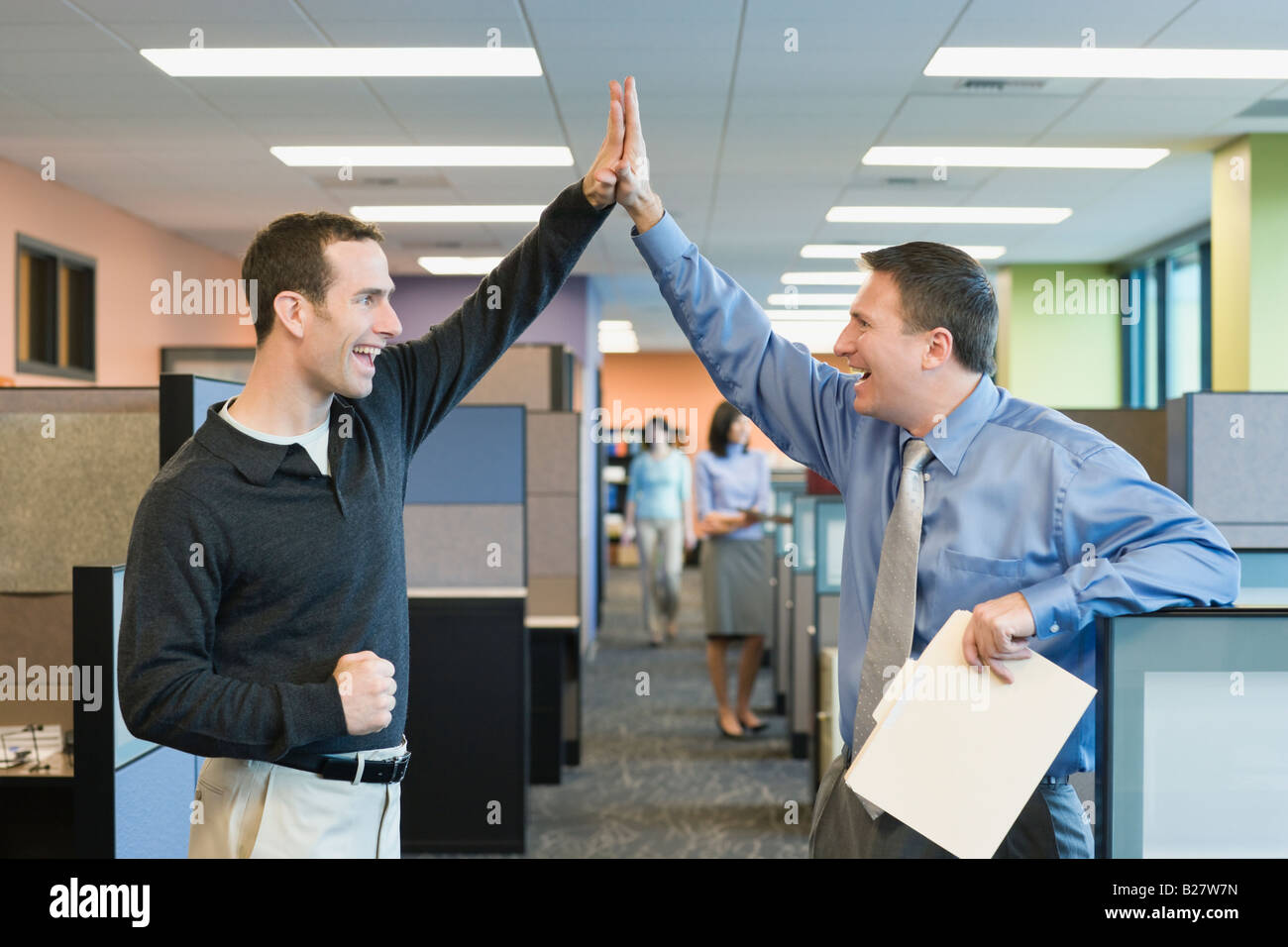 Businessmen high-fiving in office Stock Photo - Alamy