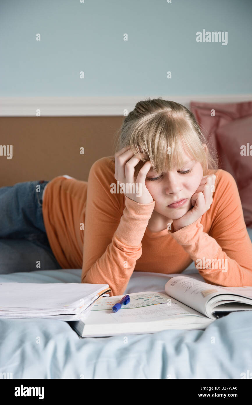 Girl doing homework on bed Stock Photo - Alamy