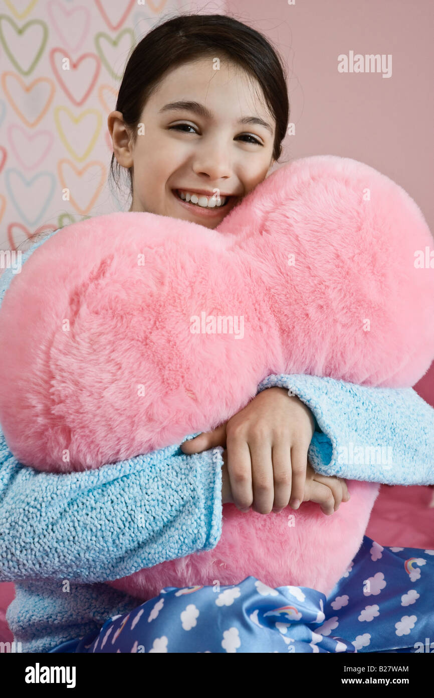 Girl hugging heart pillow Stock Photo - Alamy