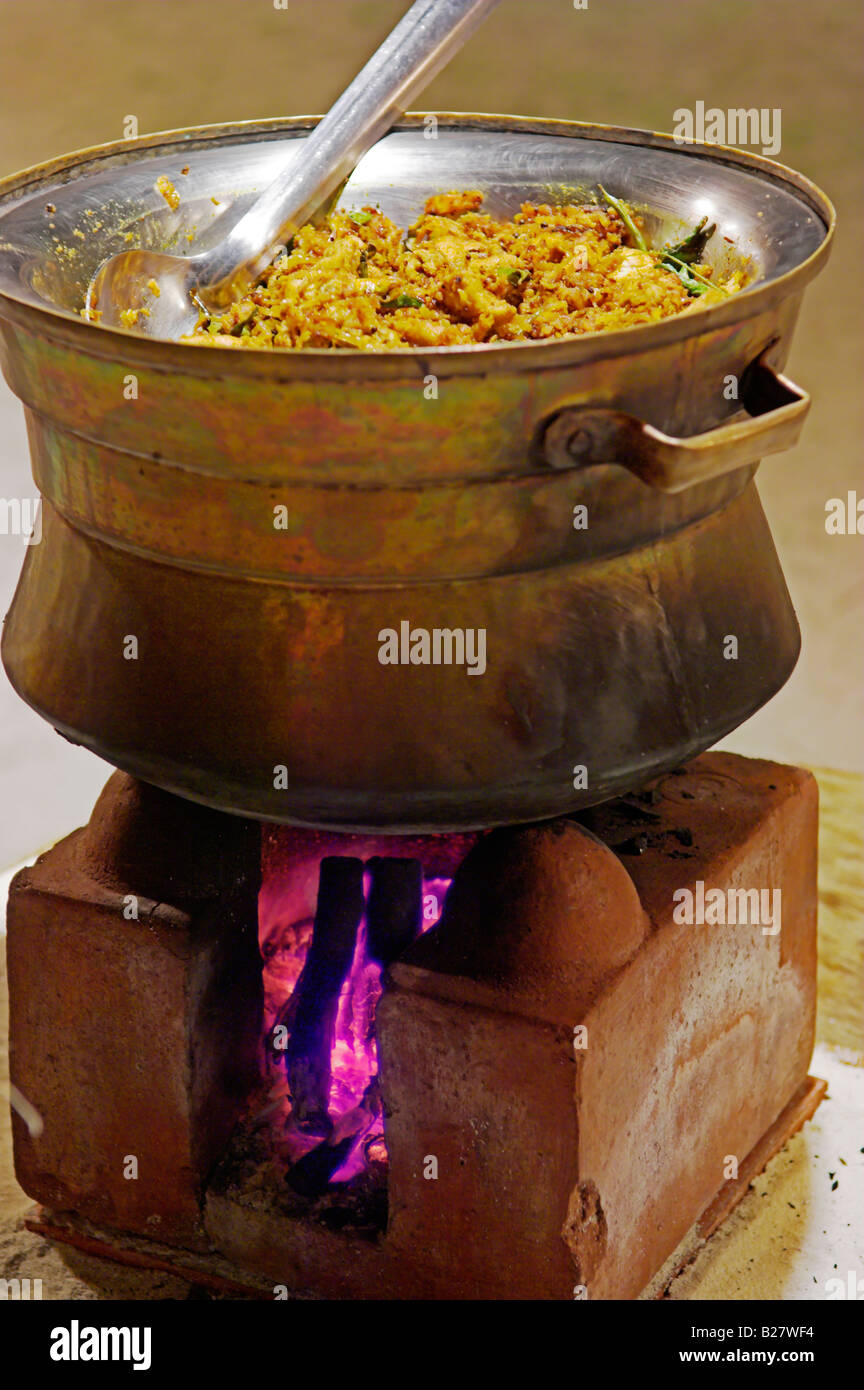 Keeping food hot in traditional metal cooking pot over open fire stove ...