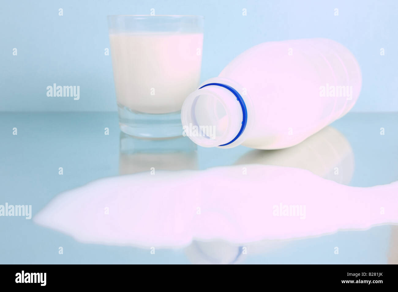 Spilt full cream milk isolated against a blue background Stock Photo ...