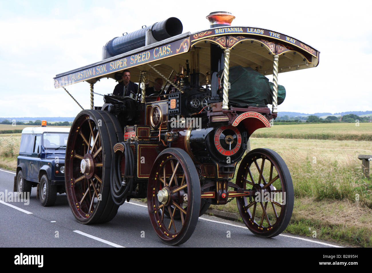 A steam-powered traction engine bowling along a quiet English country ...