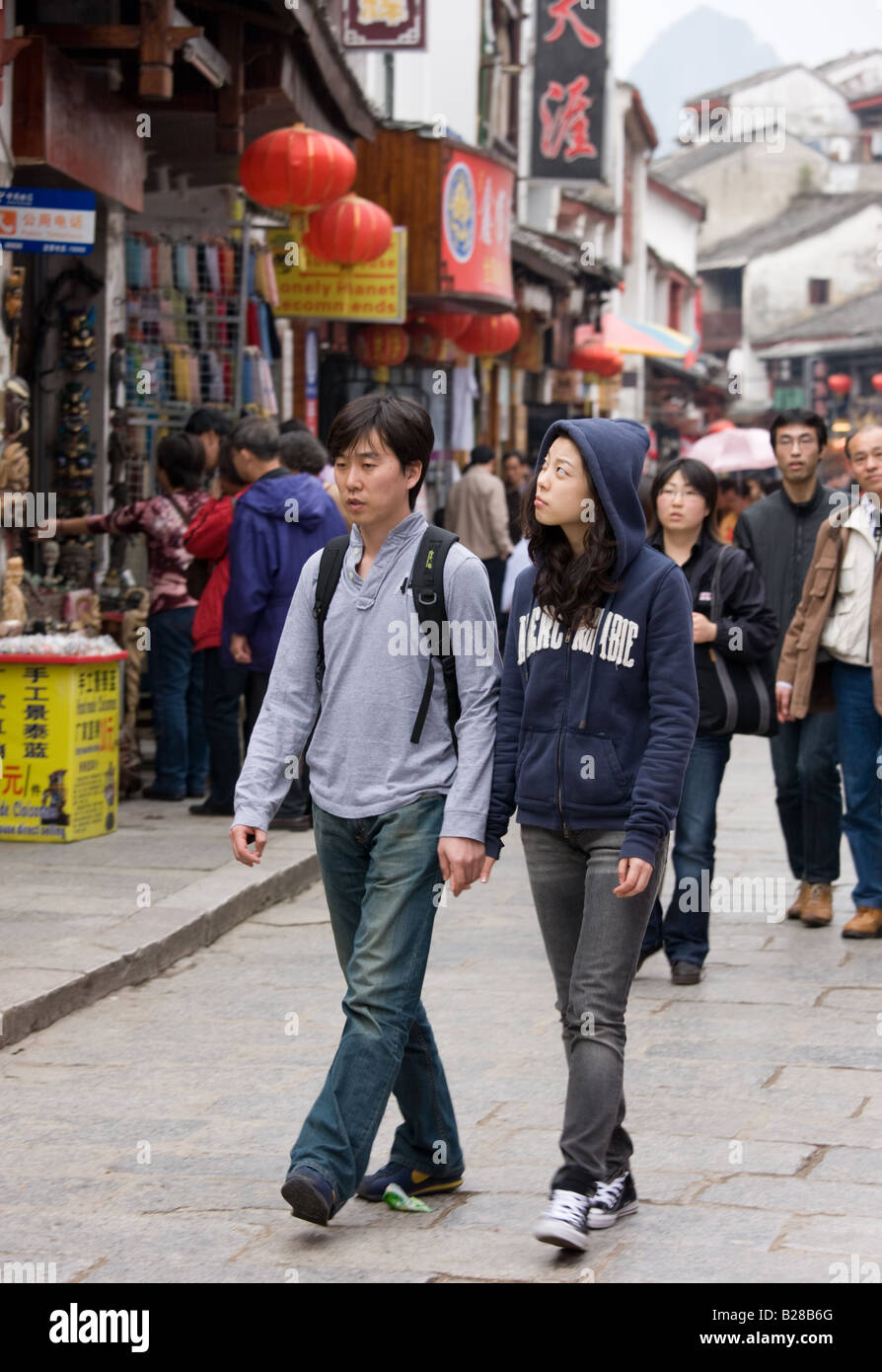 Couple walk down shopping street in Yangshuo China Stock Photo - Alamy