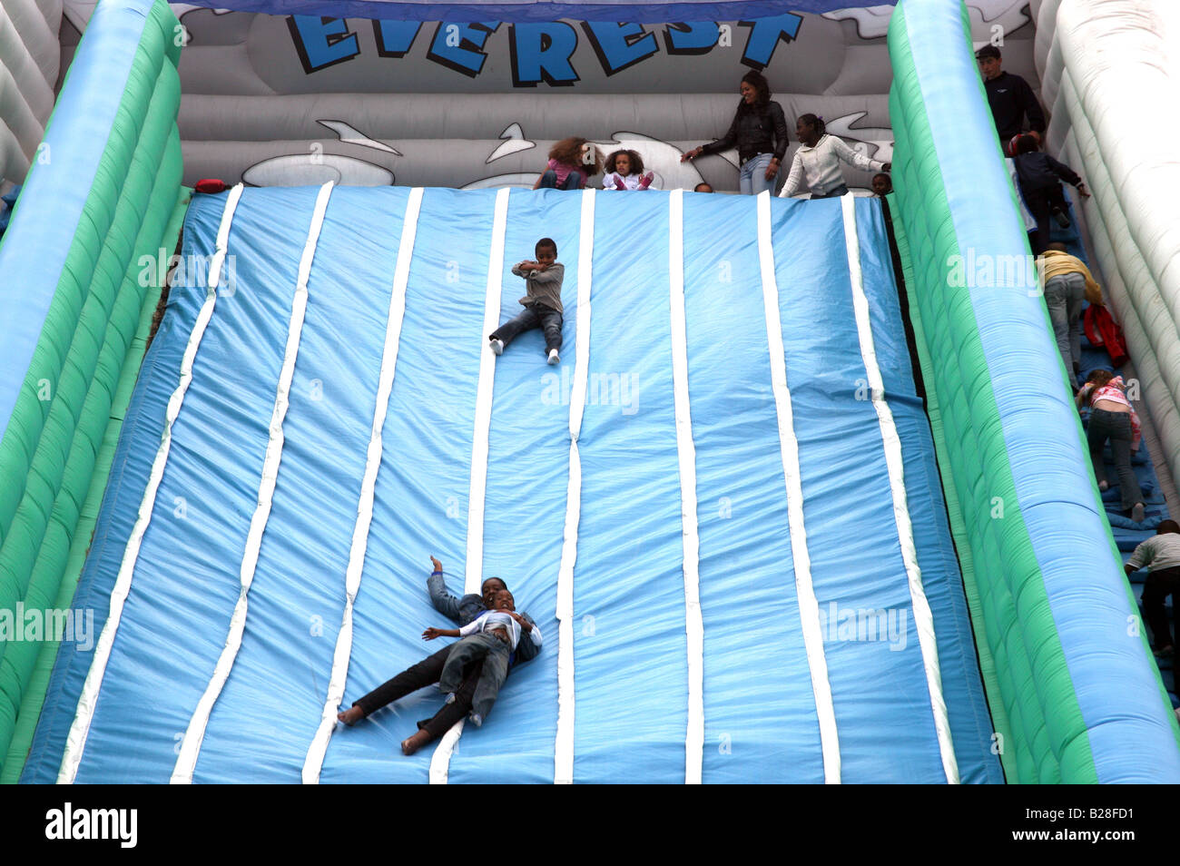 Children enjoying giant inflatable slide at London funfair Stock Photo ...