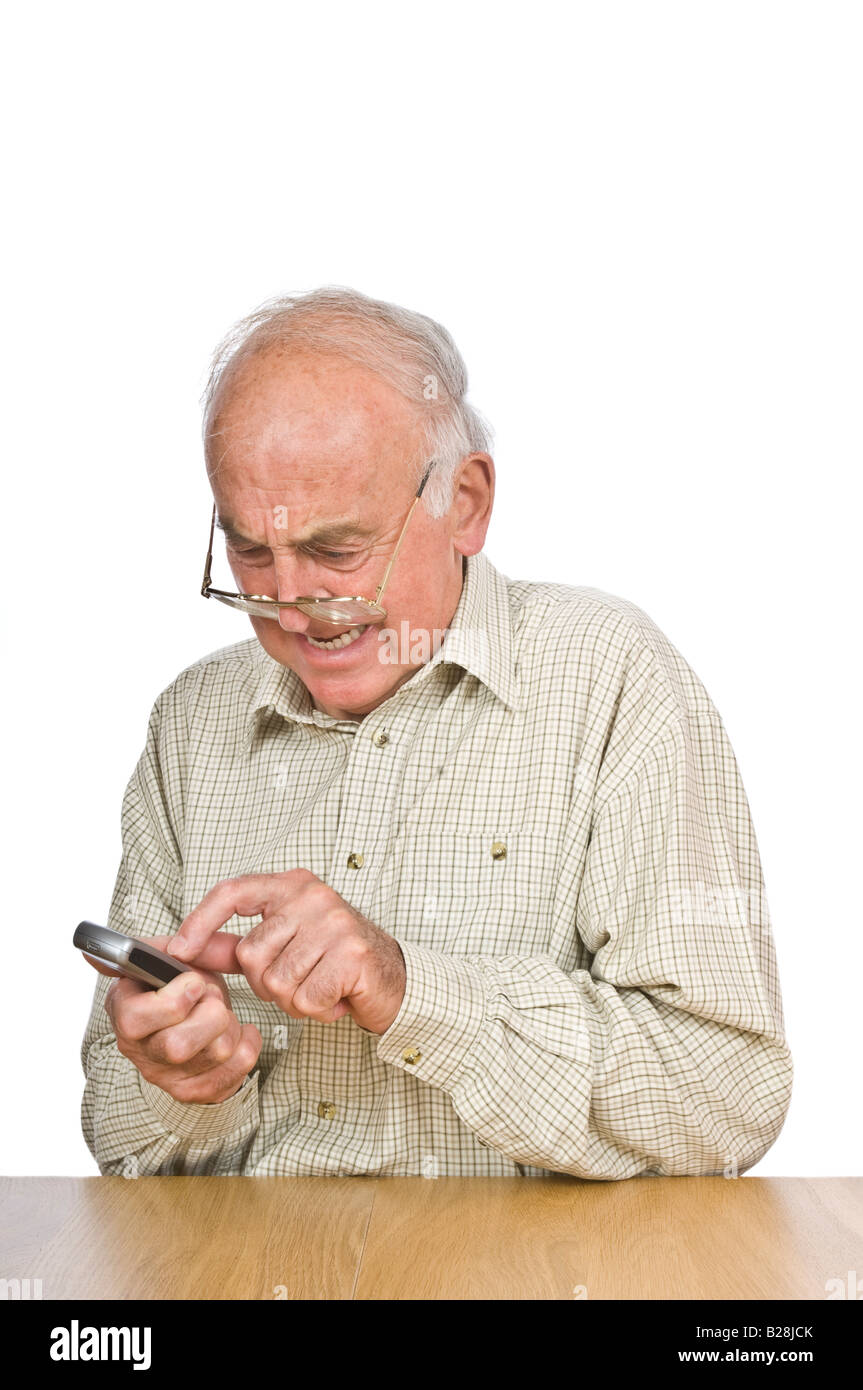 An elderly man getting frustrated trying to text or use the mobile ...