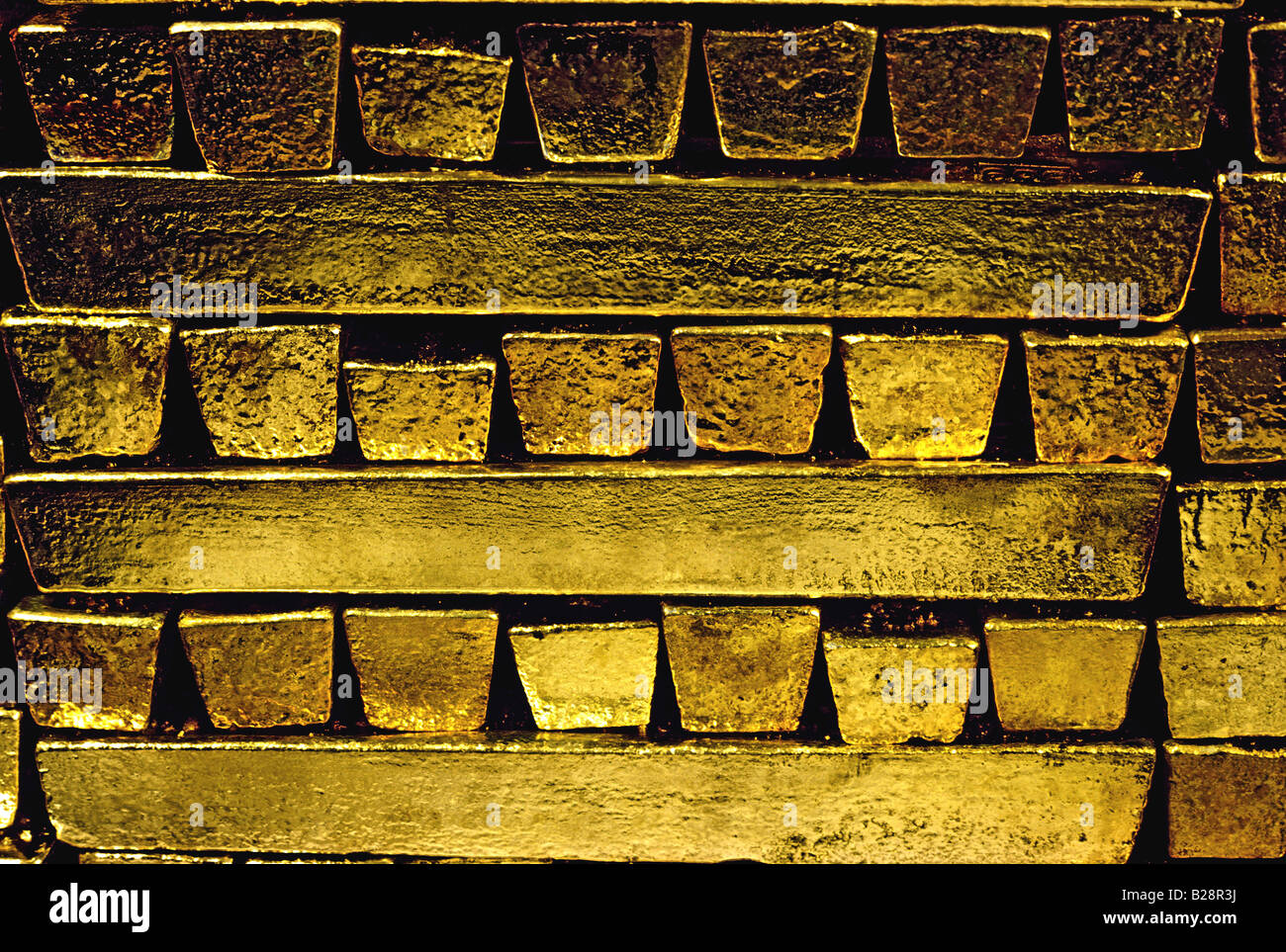 Gold bars ingots bullion pure raw closely stacked in a secure precious ...