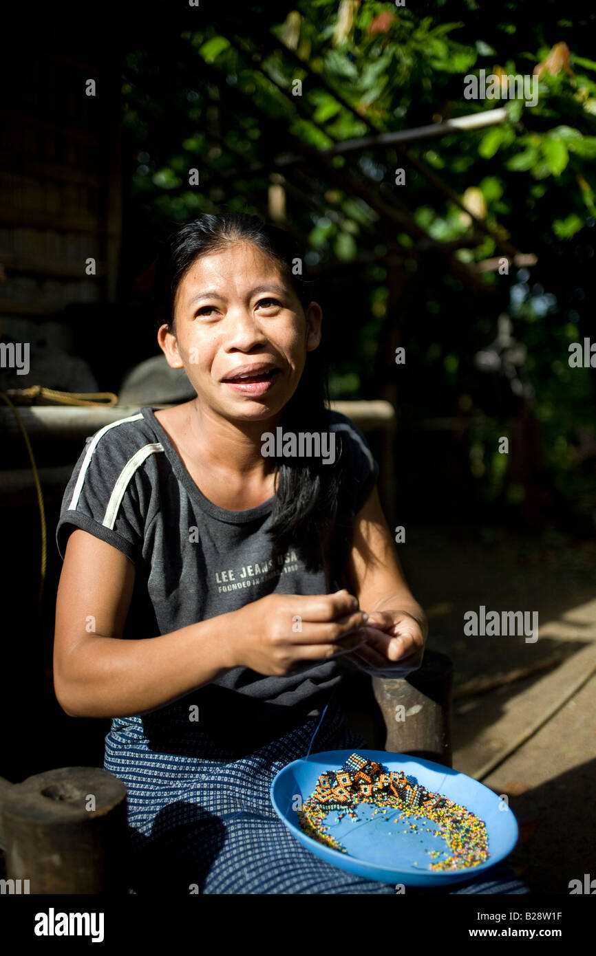 A Mangyan woman crafts a beaded cell phone case in the Panaytayan ...
