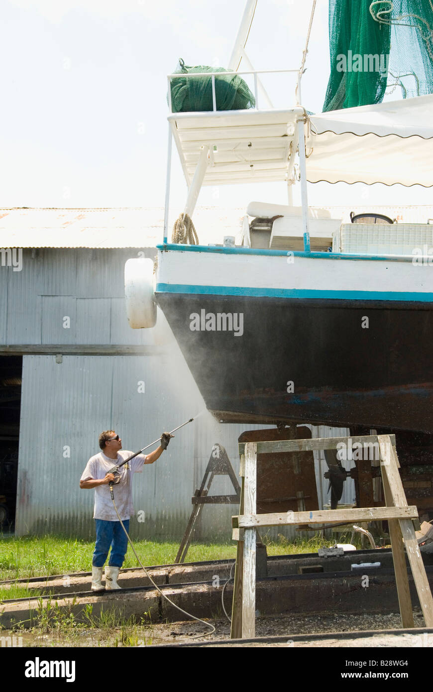 Man washing shrimp boat with a hose in Delcambre, Louisiana Stock Photo ...