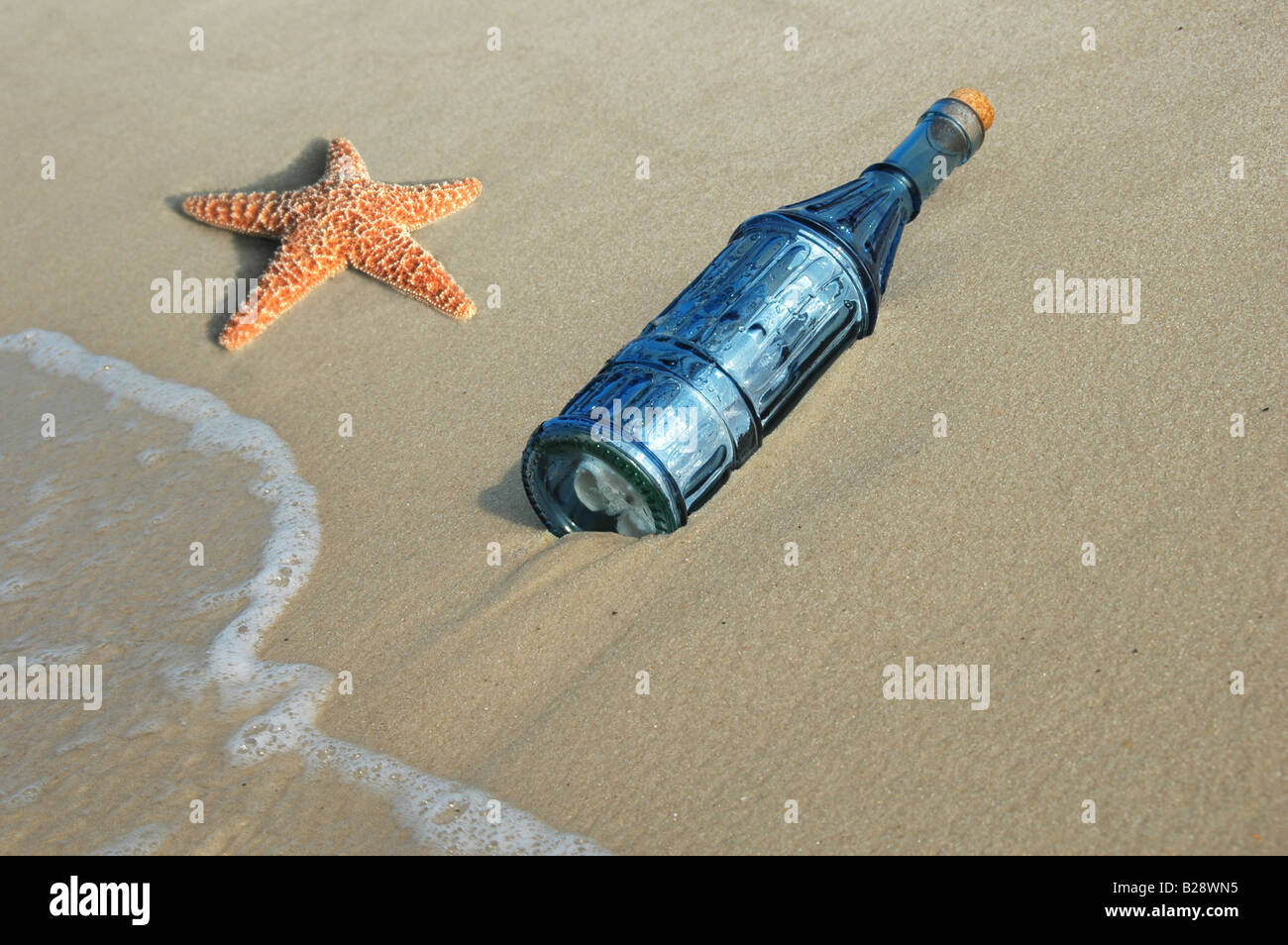 Starfish and message in a vintage bottle on the shore Stock Photo - Alamy