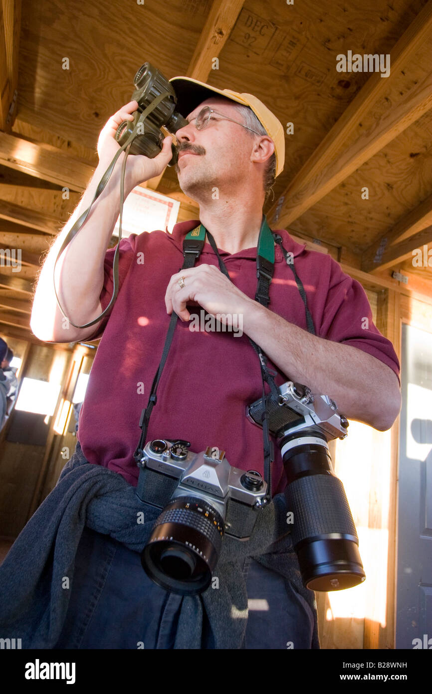 A nature watcher watches birds from a bird blind in rural Nebraska USA ...