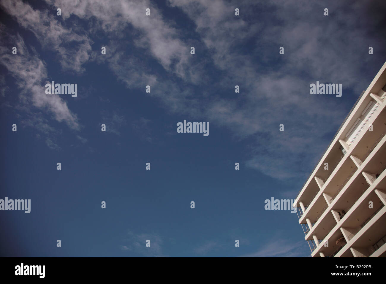 Rich blue sky with streaky clouds and white building Stock Photo - Alamy