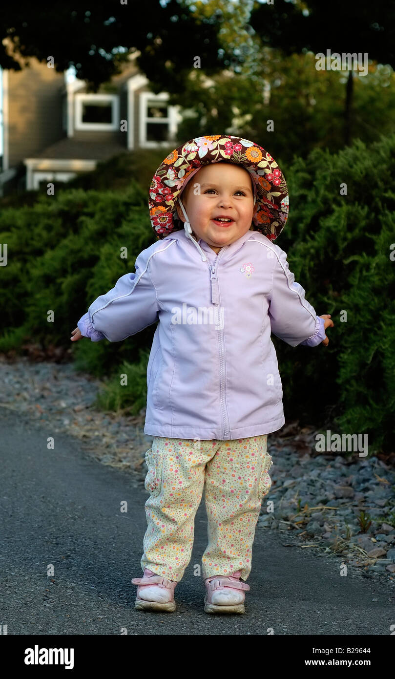 Infant girl lit by warm rays of setting sun is goofing around with nice ...