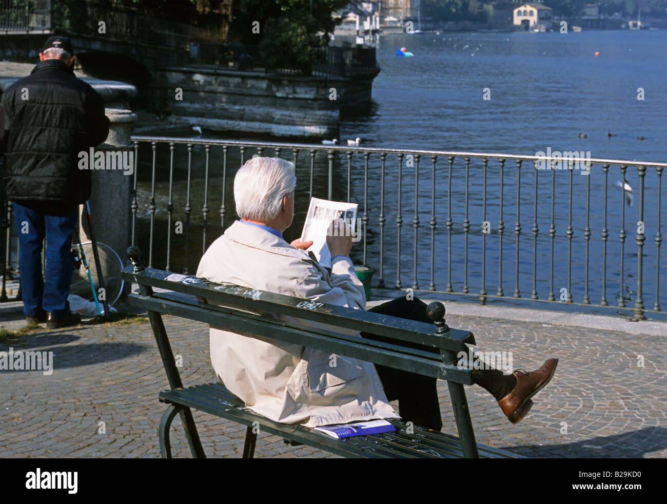 Man with magazine / Lake Como Stock Photo - Alamy
