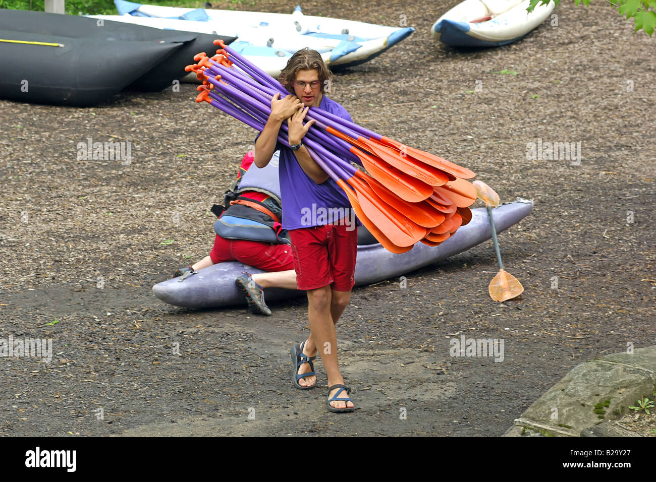 Worker at the Ohiopyle Rafting centre carrying paddles to hand out to ...