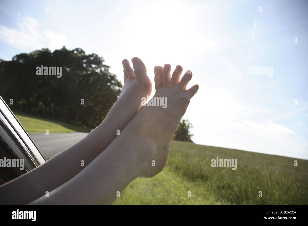 feet sticking out of car window Stock Photo - Alamy