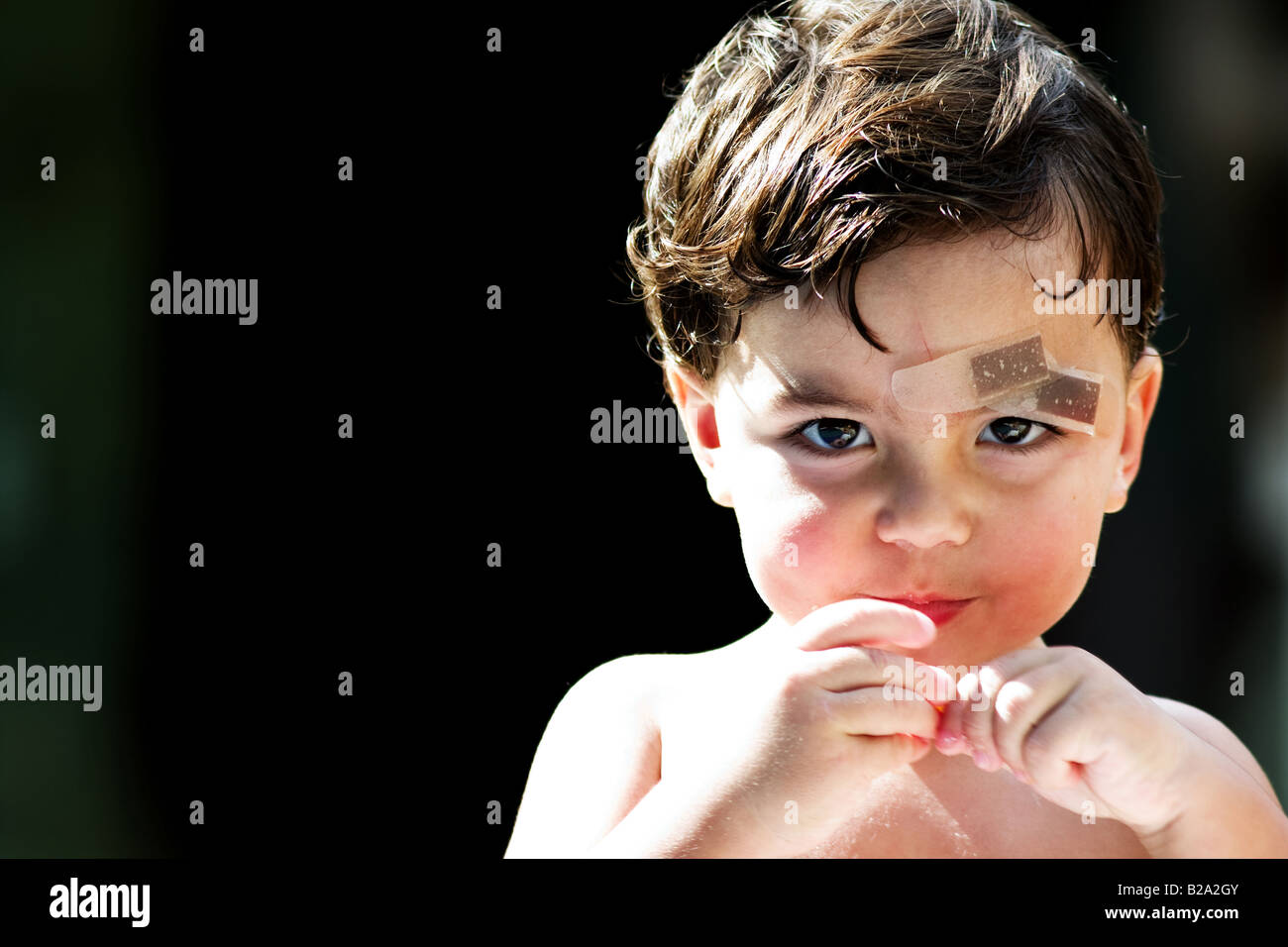 Smiling boy with band-aids on forehead Stock Photo - Alamy