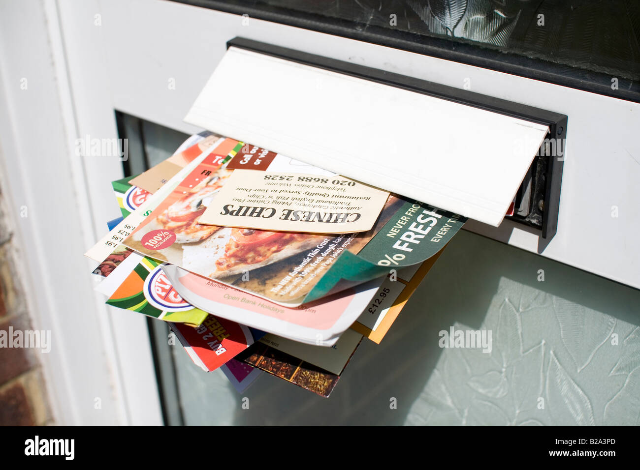 Junk mail in a letterbox Stock Photo - Alamy