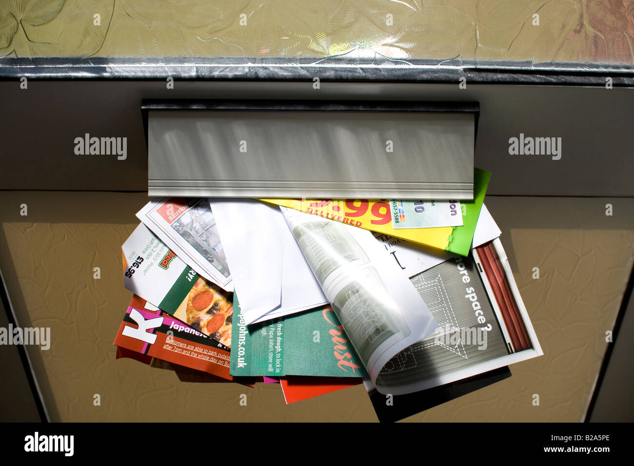 Junk mail in a letterbox Stock Photo - Alamy