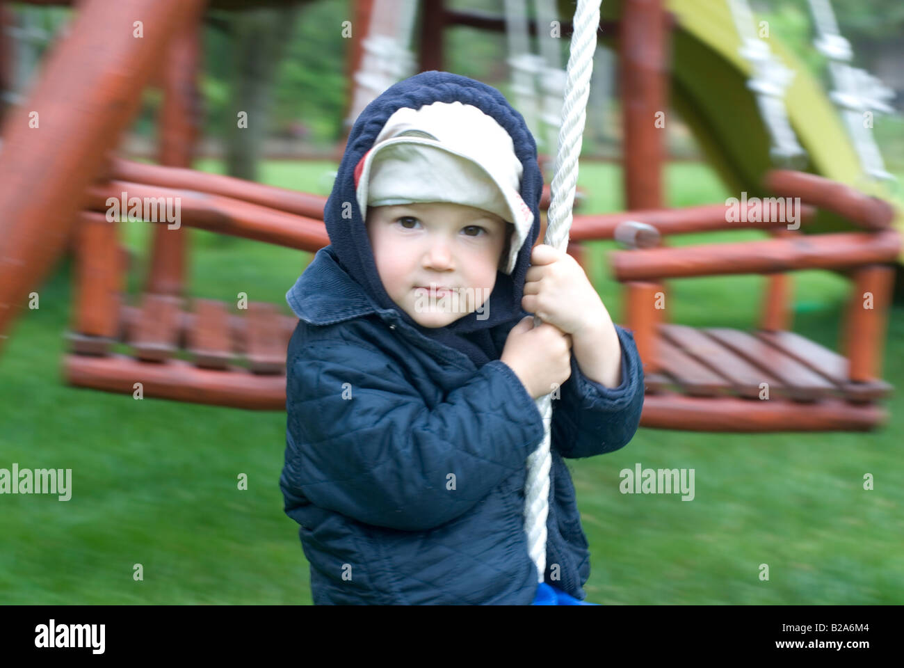 Boy swinging on garden rope hi-res stock photography and images - Alamy