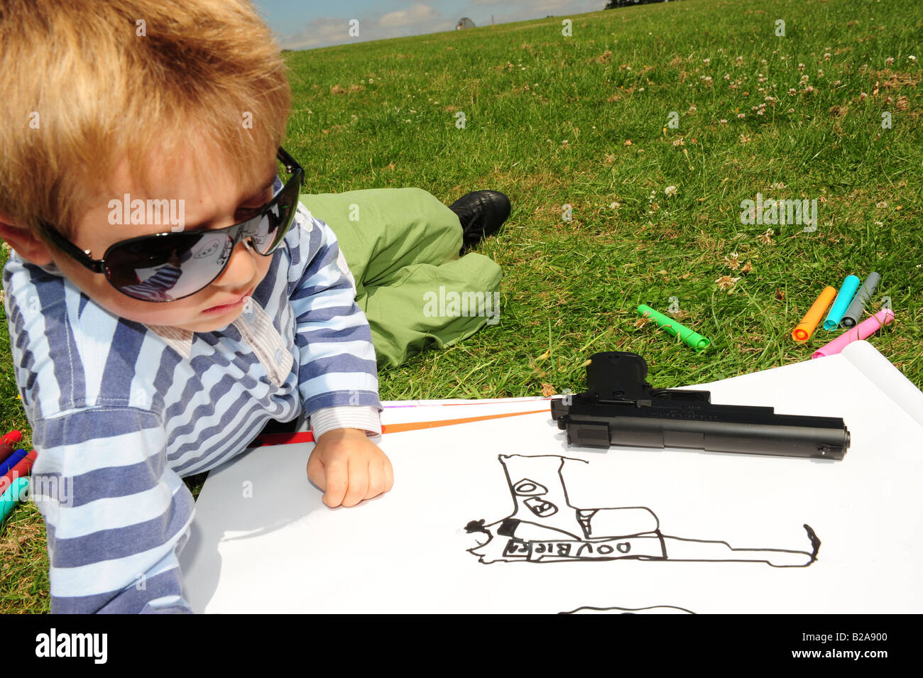 small boy drawing a picture of his toy gun in the park Stock Photo - Alamy