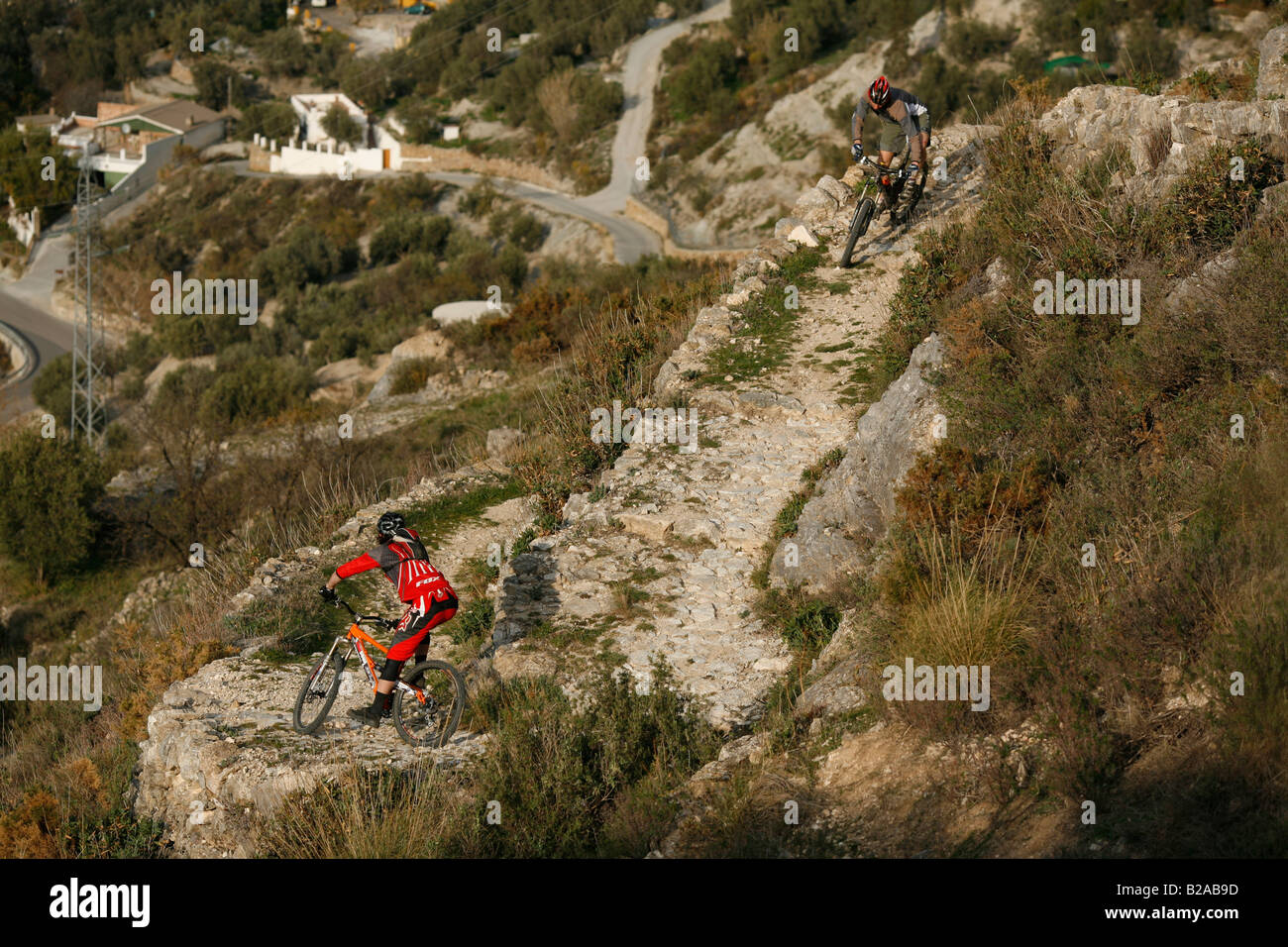 Two Mountain Bikers ride switch backs near town in the Sierra Nevada ...