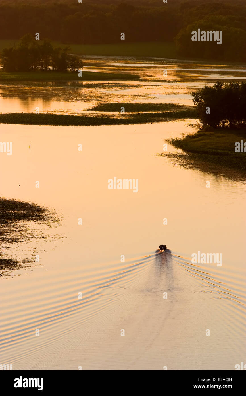 A single boat moves up the Mississippi River as the water catches the ...