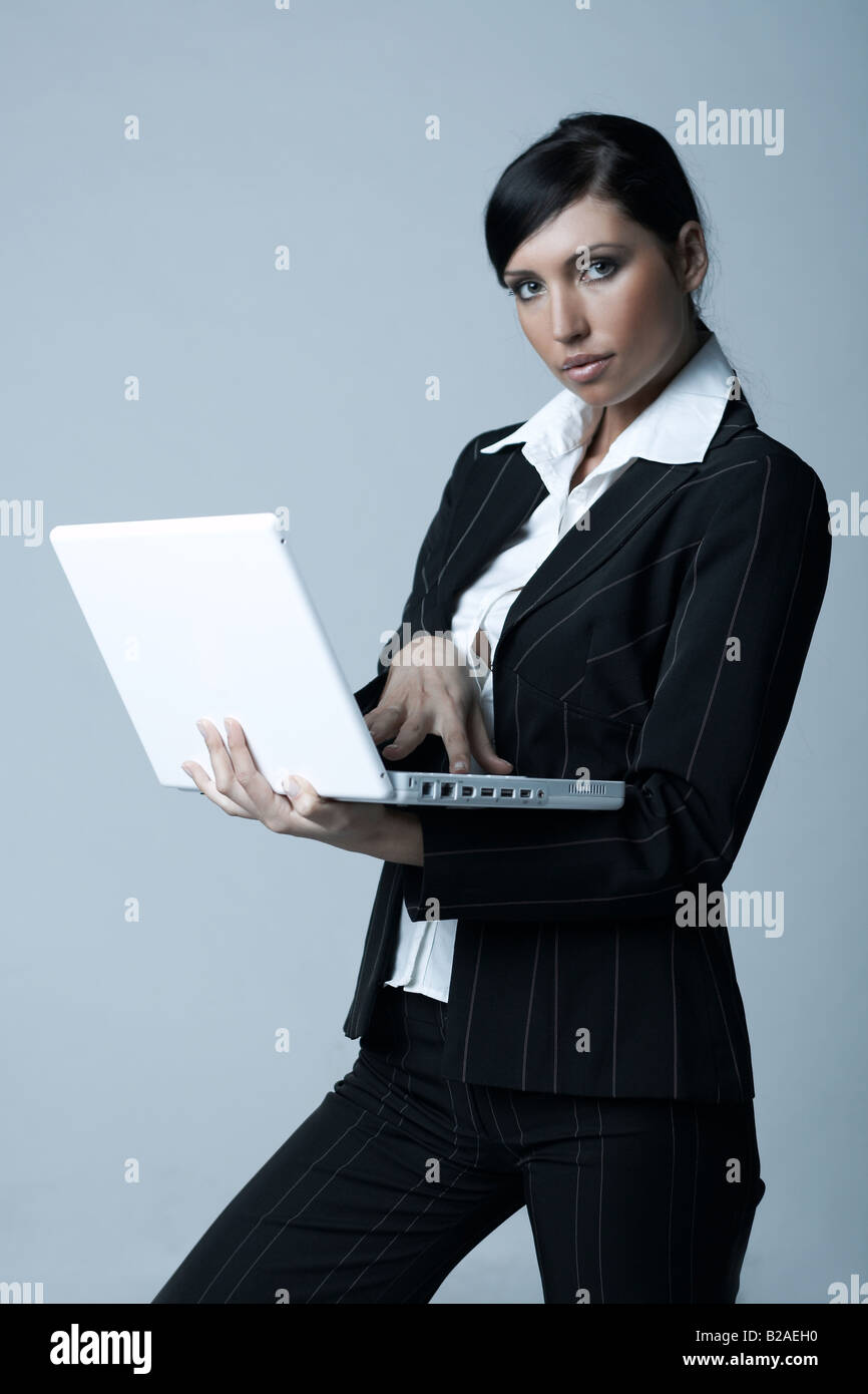 Beautiful brunette business woman with laptop computer isolated on ...