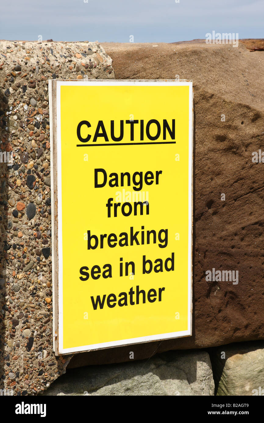 Safety warning sign on a harbour wall at Whitby, North Yorkshire ...