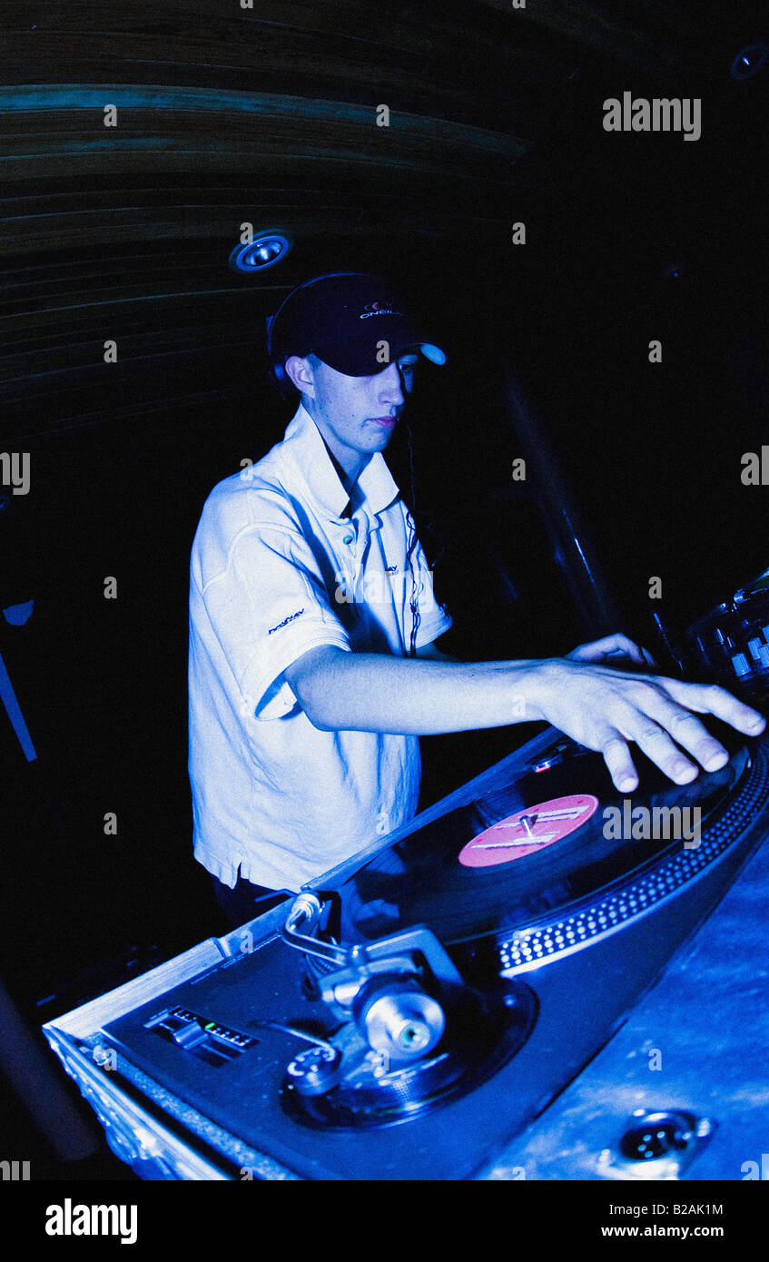 Young caucasian male wearing a white polo shirt and baseball cap, DJing ...
