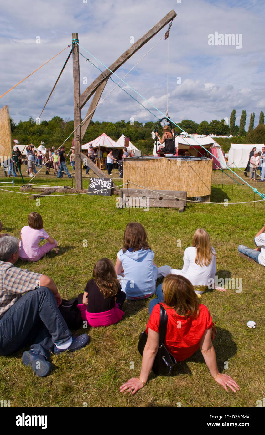 Spectators wait for woman on ducking stool to drop into water tank ...