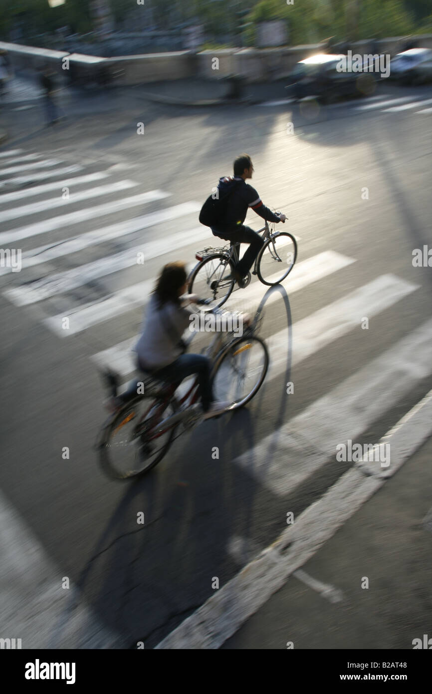 two people riding fast bike on quiet city street Stock Photo - Alamy