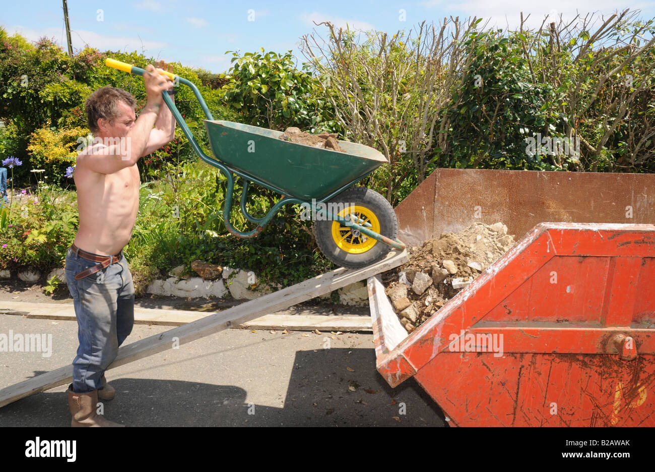Man loading skip Stock Photo - Alamy