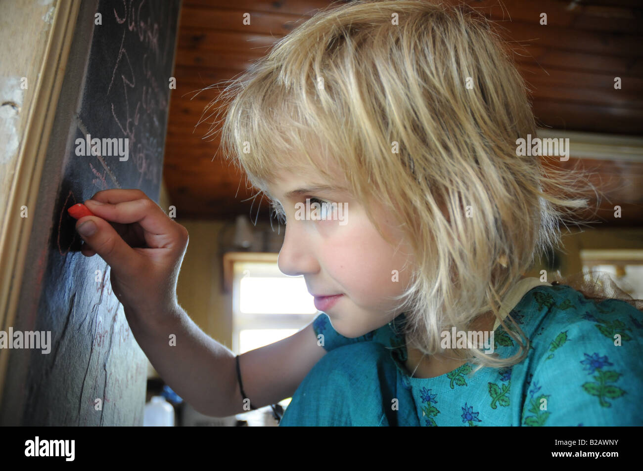 Young child writing on chalkboard Stock Photo - Alamy