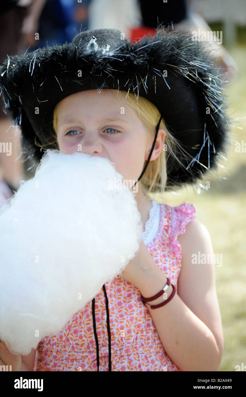 Royalty free photograph of a little girl eating candy floss at a music ...