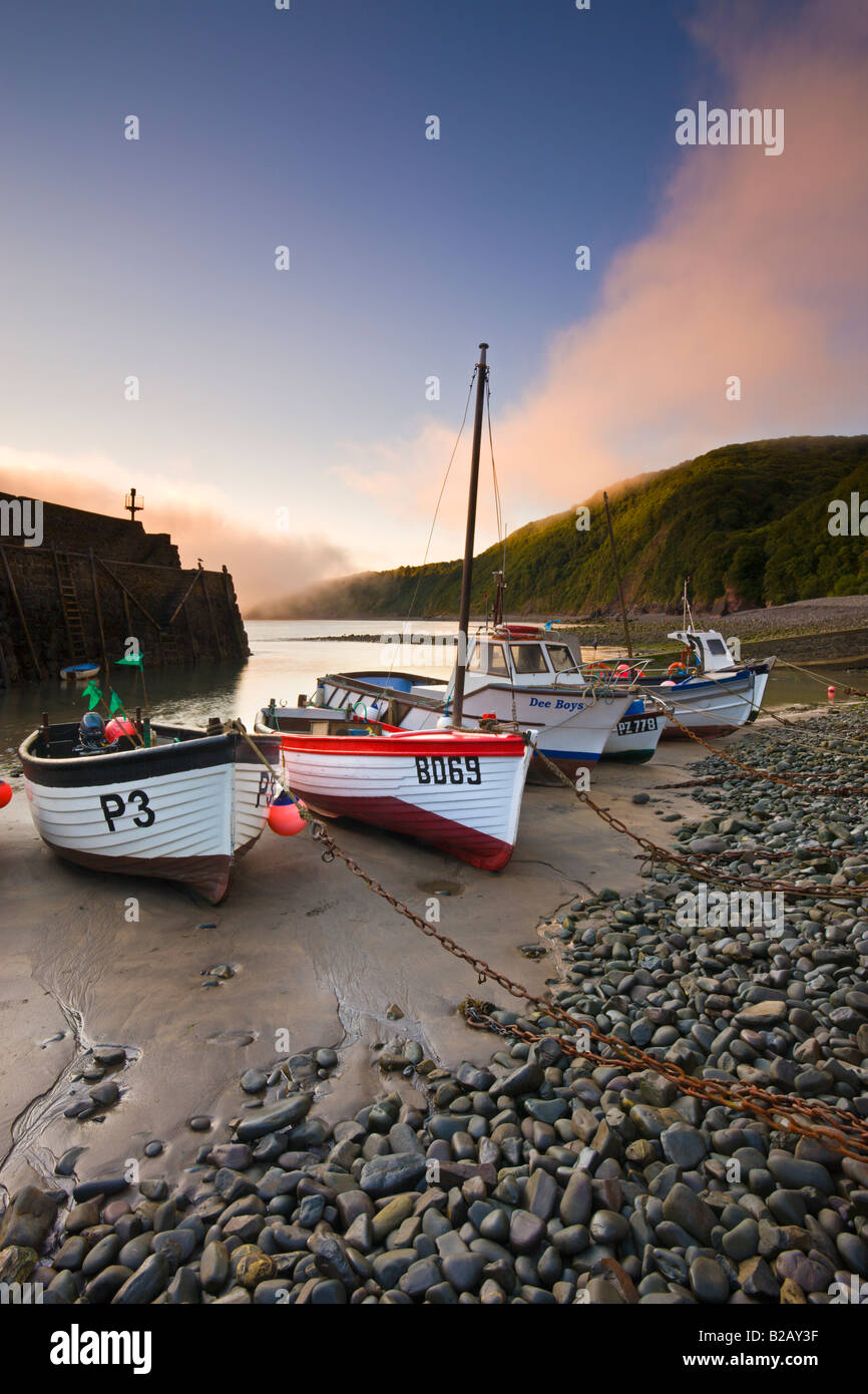 Fishing vessels beached at low tide in Clovelly harbour Devon England ...