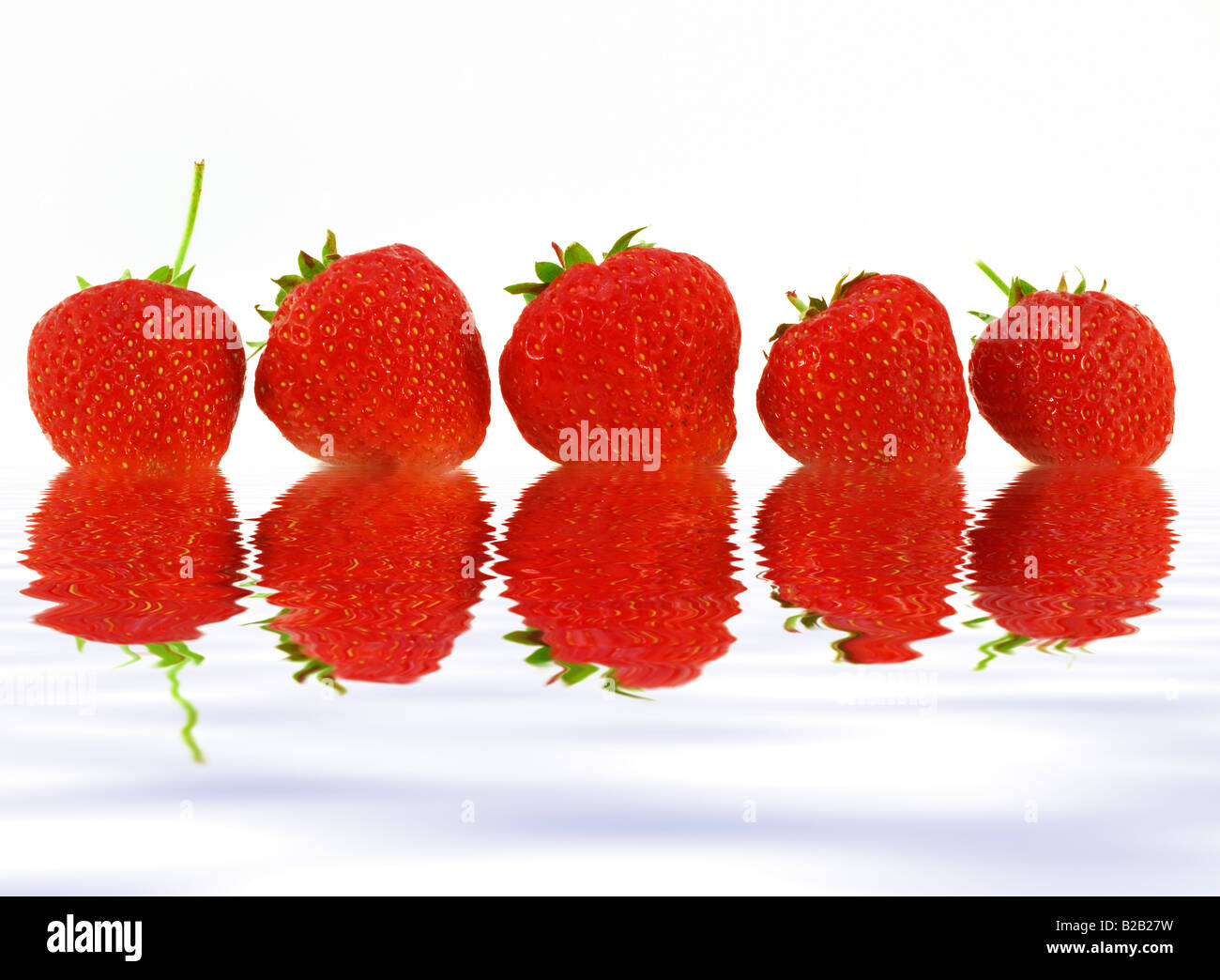 five fresh strawberries on a white background Stock Photo - Alamy
