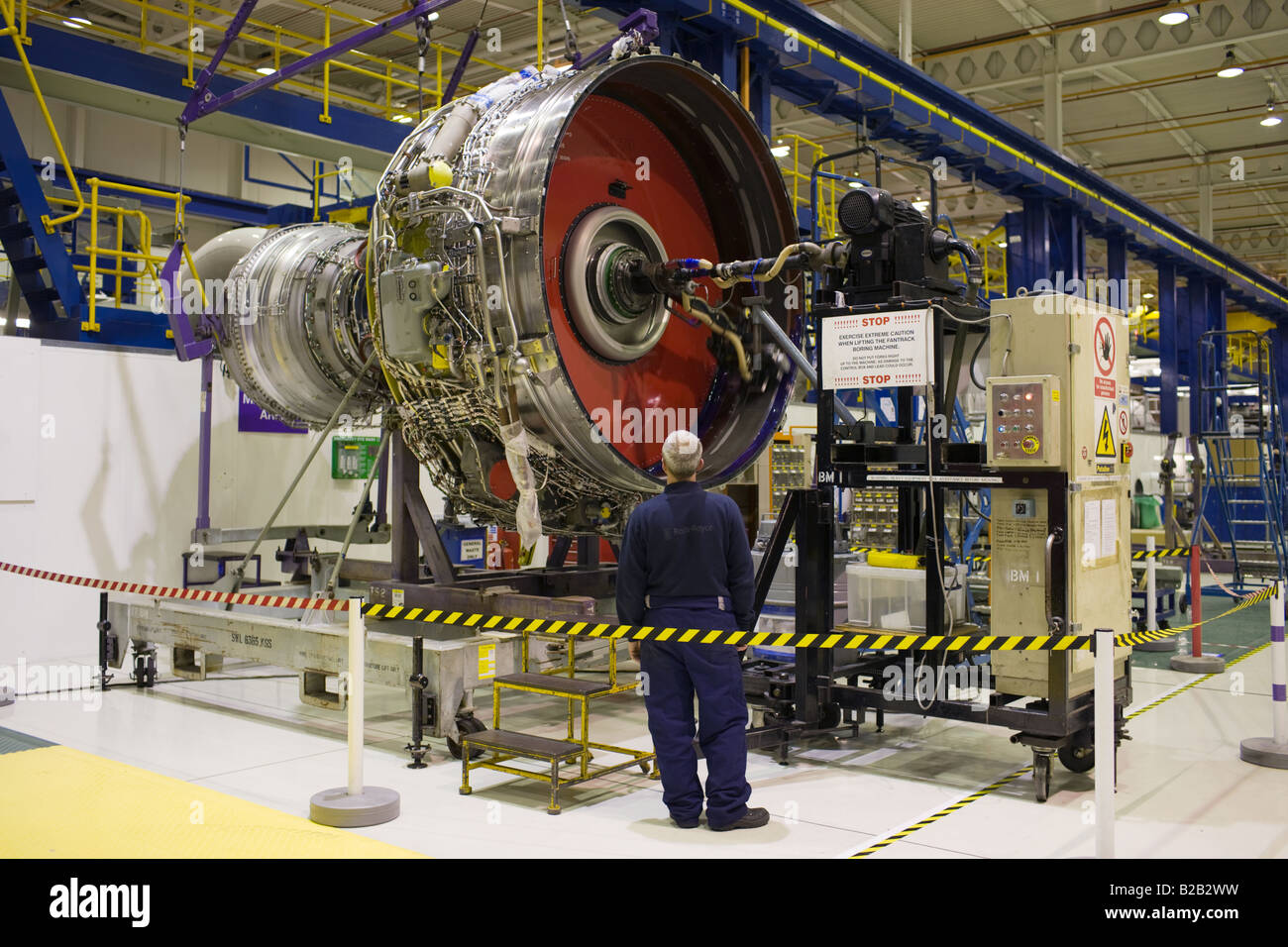 Enginer works on a Rolls Royce jet engine in the production factory ...