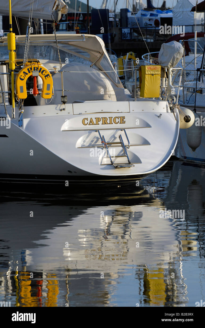 Stern of sailing yacht lit by evening sunshine in a Solent marina Stock ...