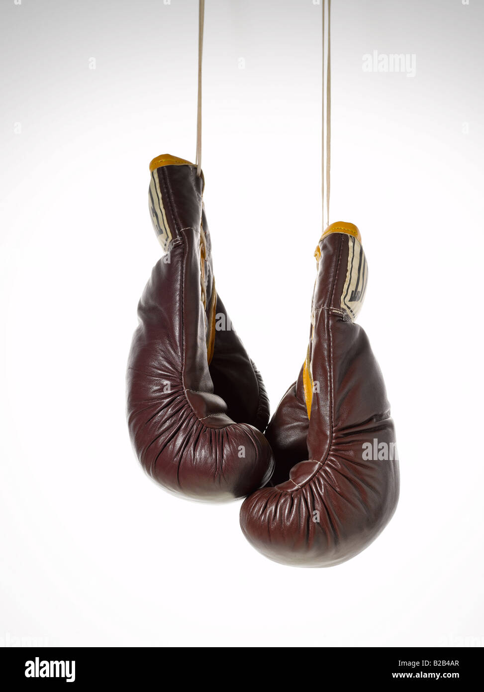 pair of brown vintage brown leather boxing gloves hanging with strings ...