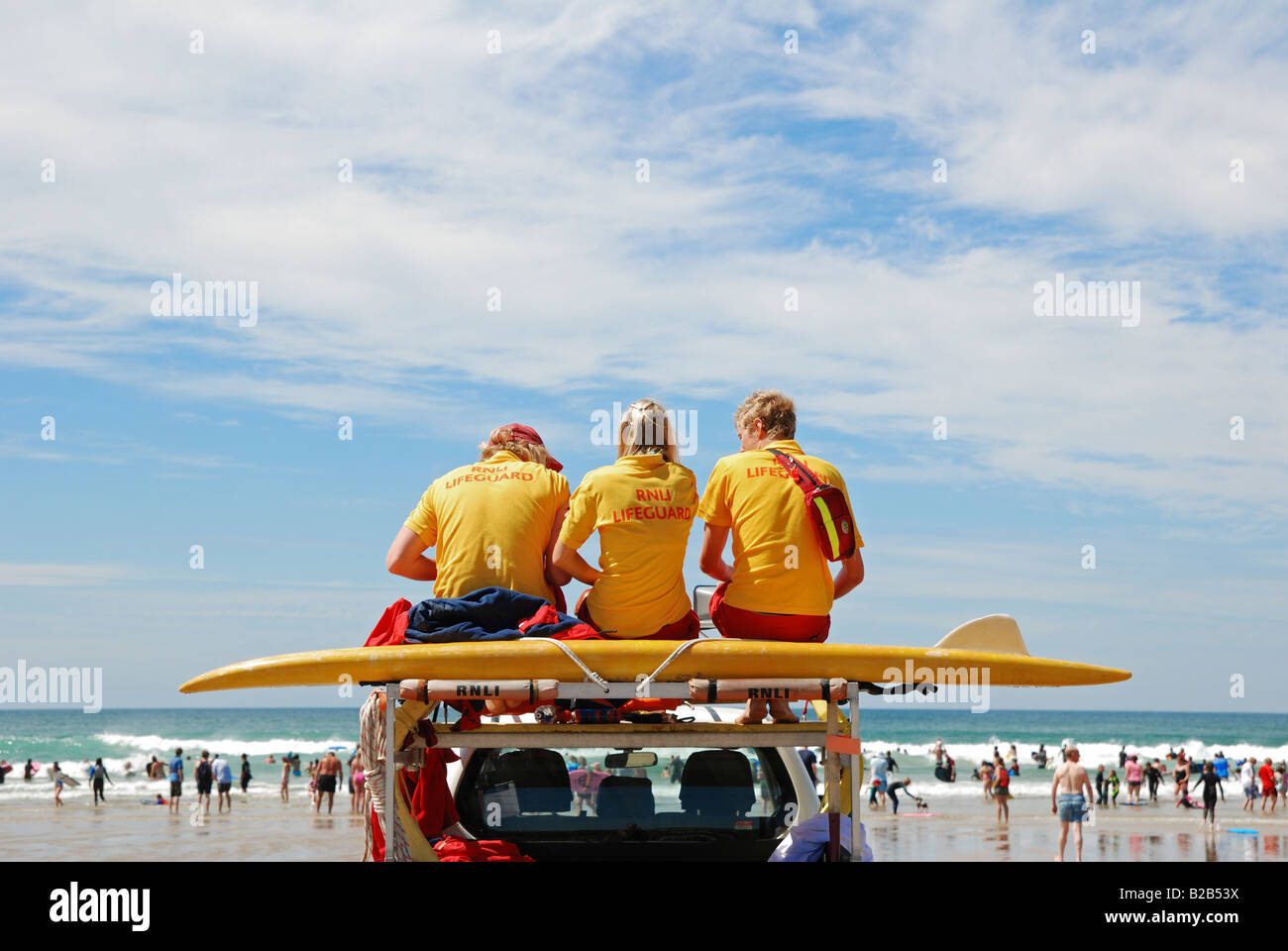 three lifeguards sitting on the top of their rescue vehicle whilst ...
