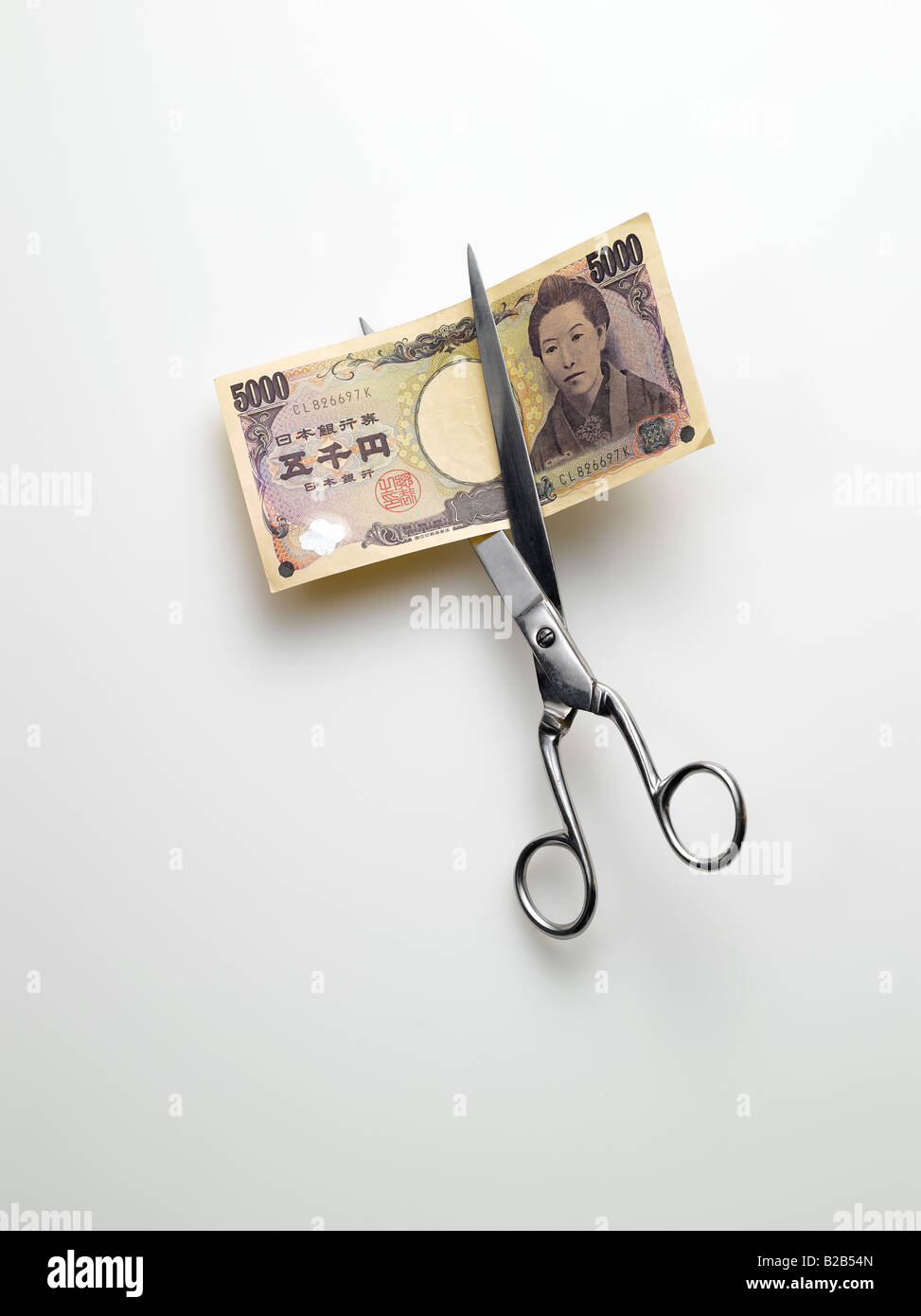 scissors cutting Japanese yen money on white background Stock Photo - Alamy
